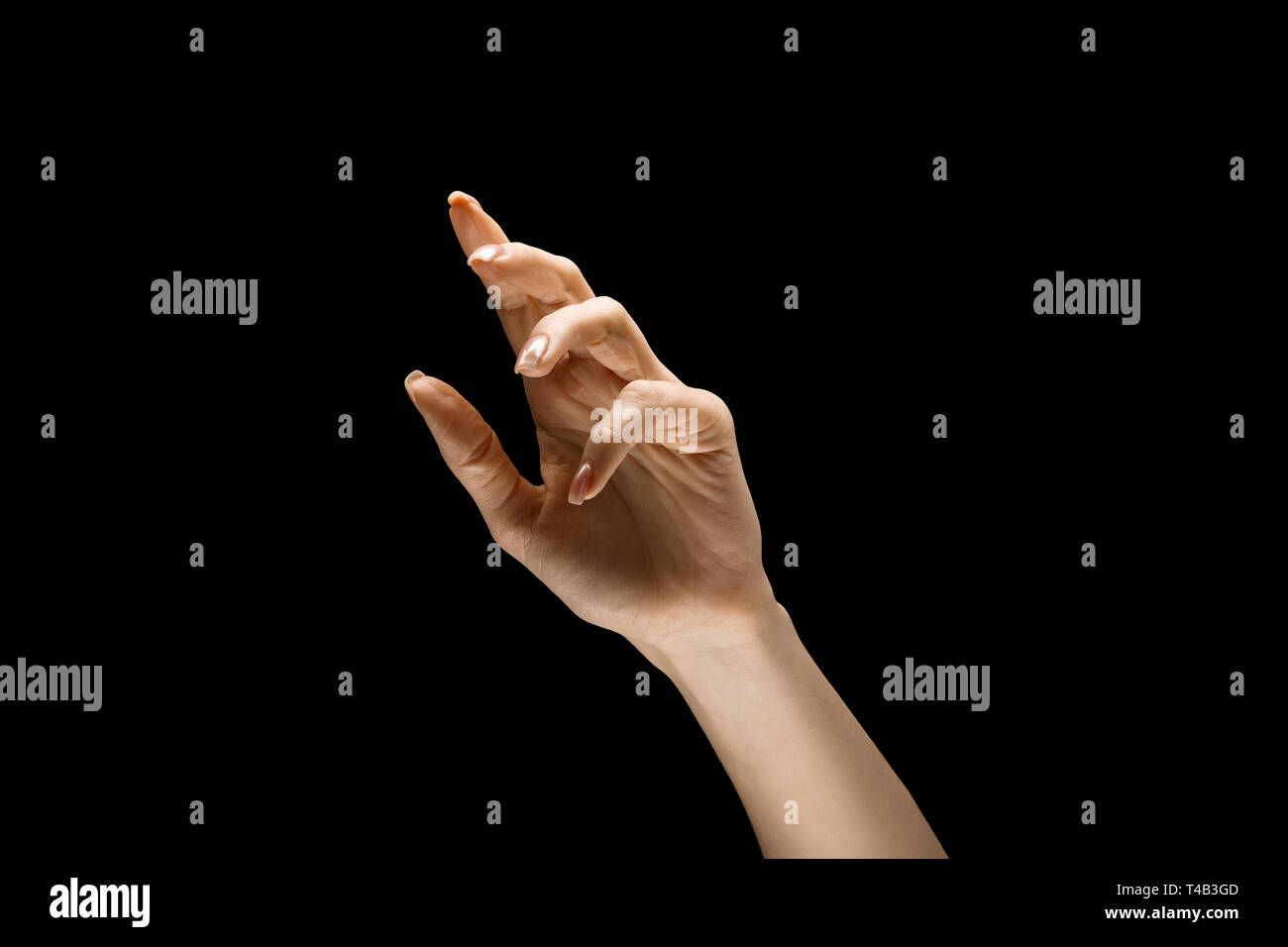 Female hand demonstrating a gesture of getting touch isolated on black ...
