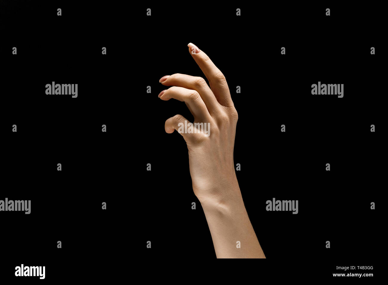 Female hand demonstrating a gesture of getting touch isolated on black ...