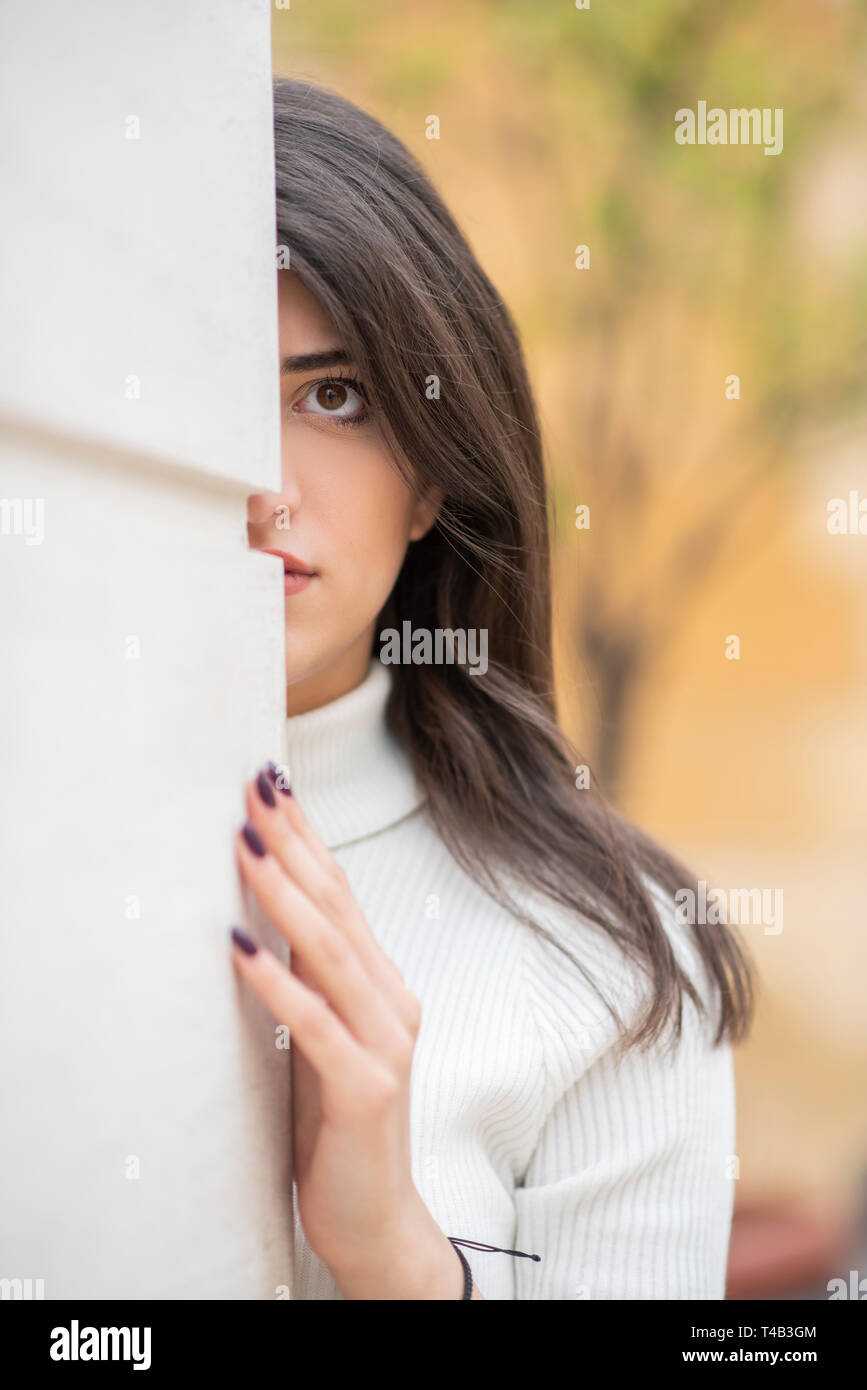 Scared young woman hiding outdoors Stock Photo - Alamy