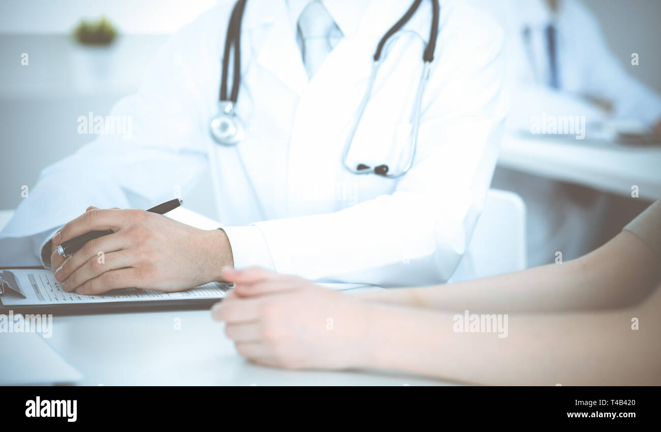 Doctor and patient are discussing something, just hands at the table ...