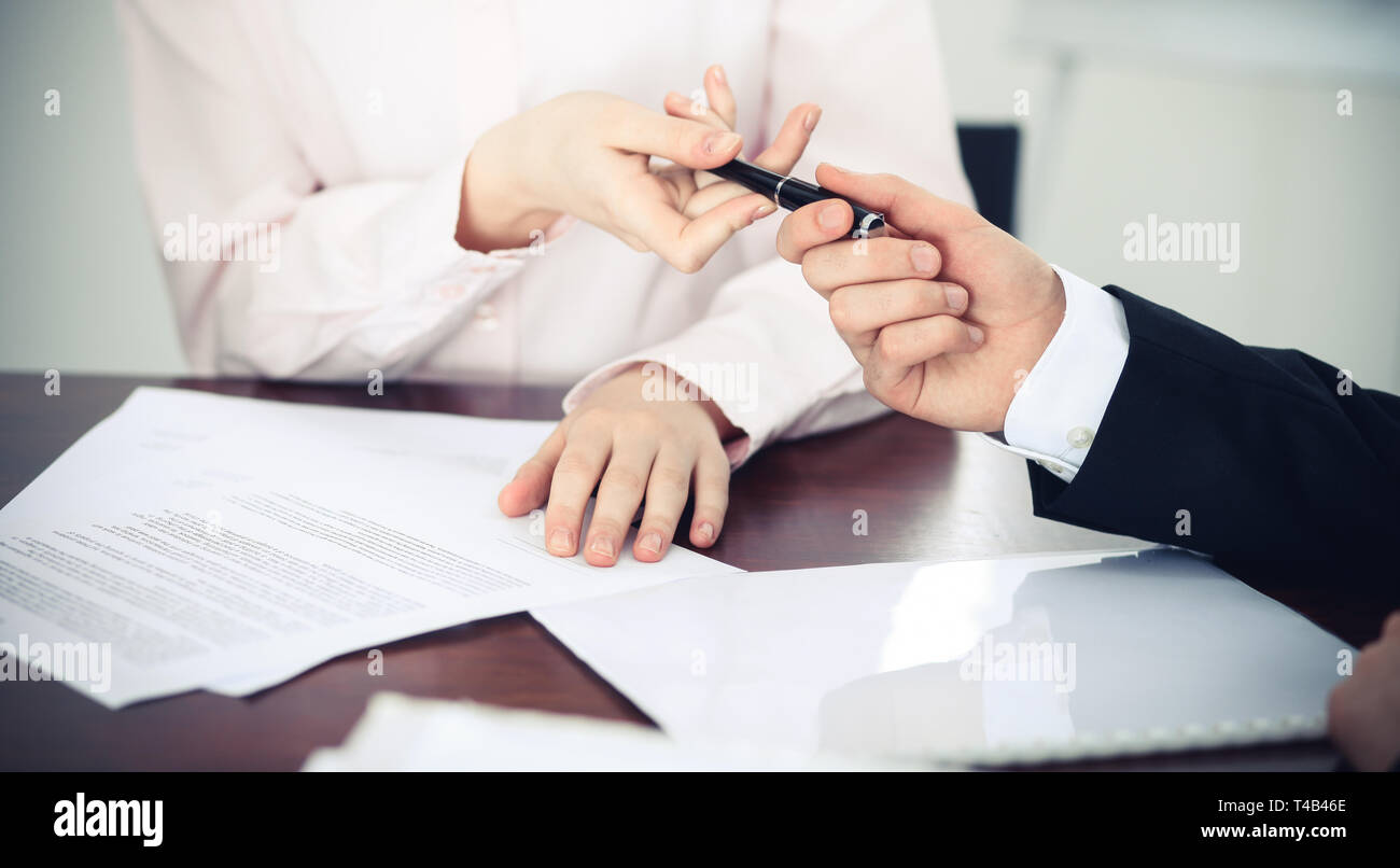 Business women giving a pen to businessman for contract signing ...