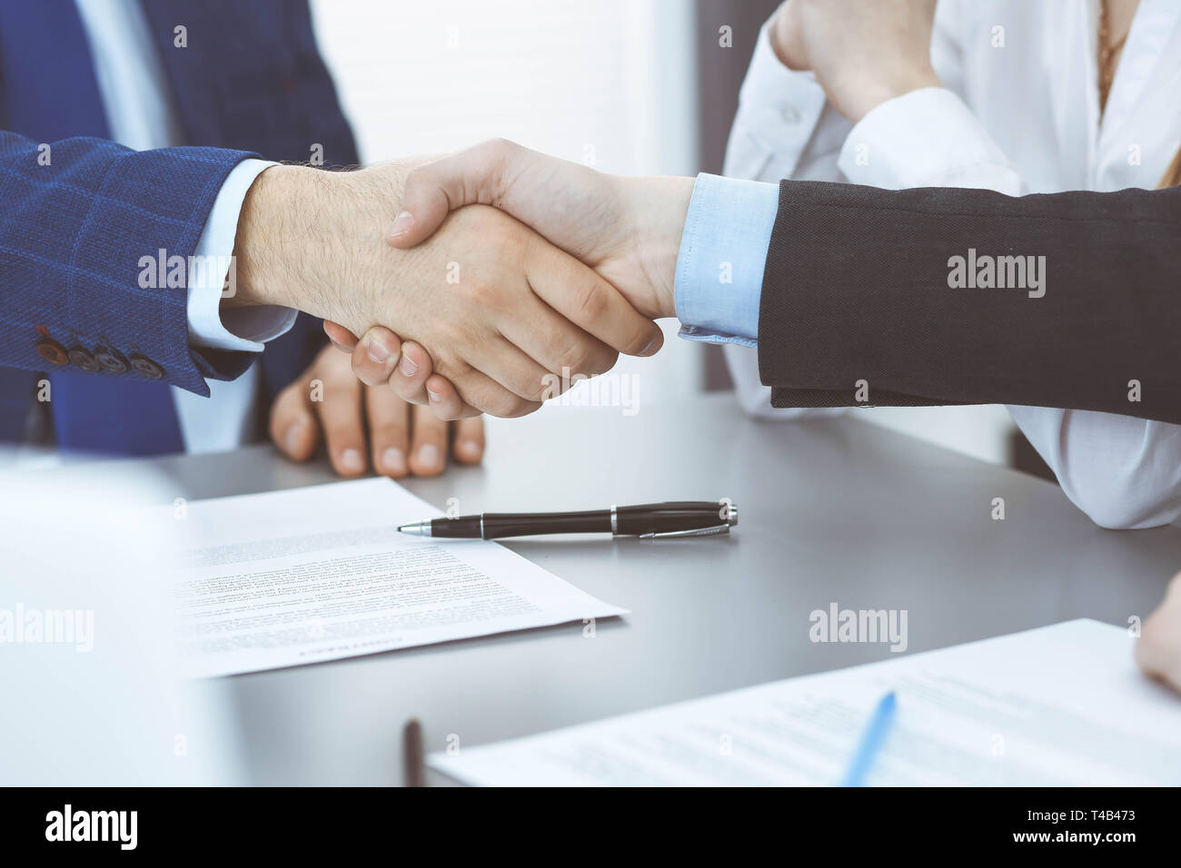 Business people shaking hands, finishing up a papers signing. Meeting ...
