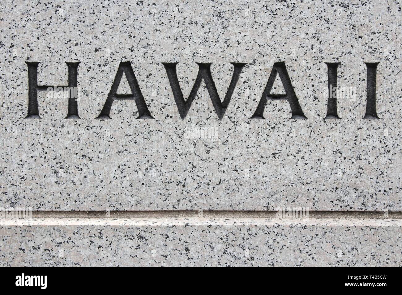 Hawaii - US state name carved in grey granite stone Stock Photo - Alamy