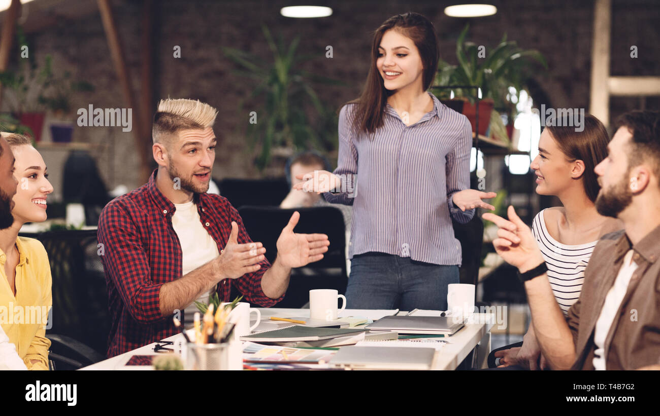 Designer giving new ideas about project to his partners Stock Photo - Alamy