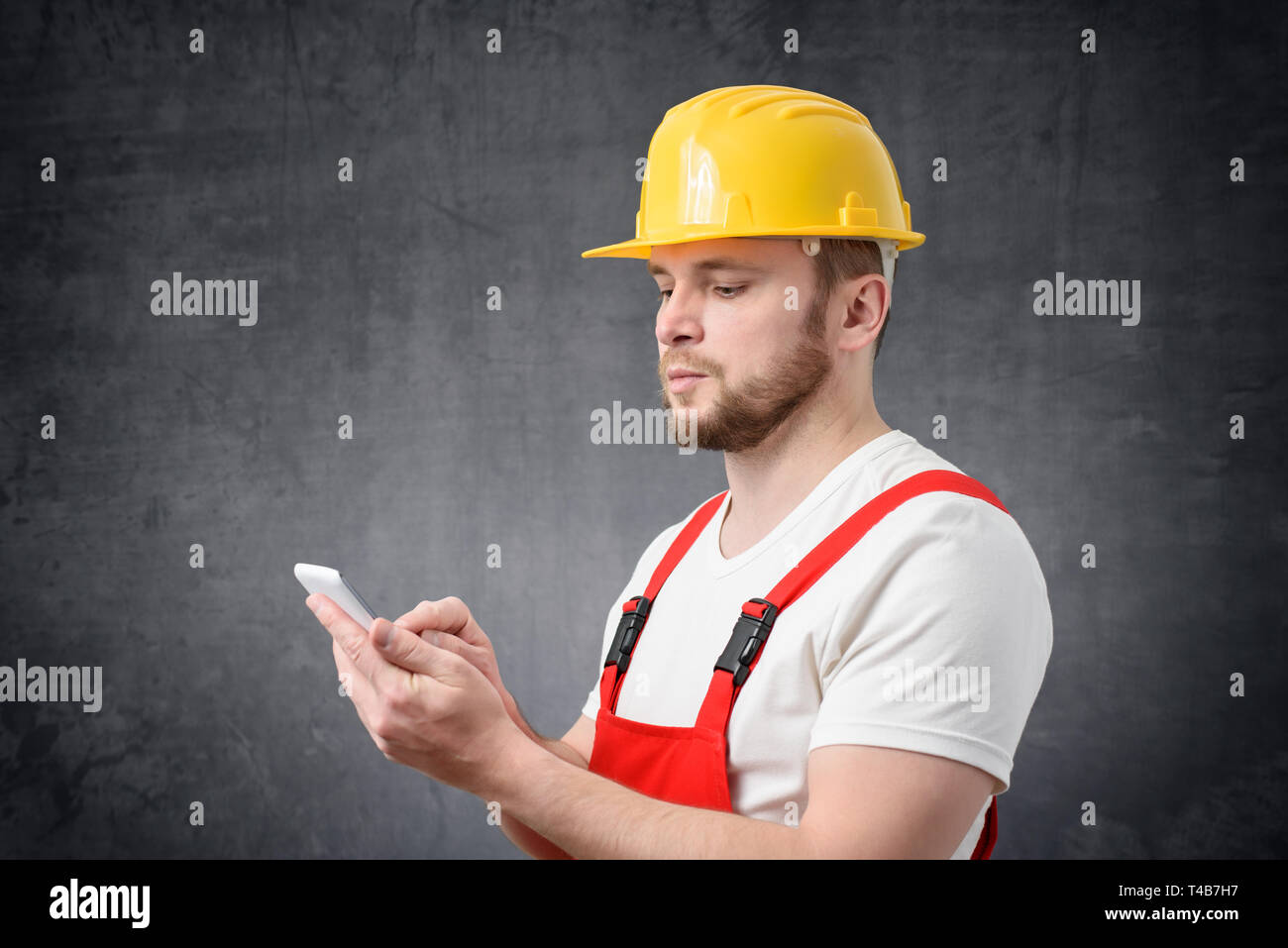 Construction worker using smartphone Stock Photo - Alamy