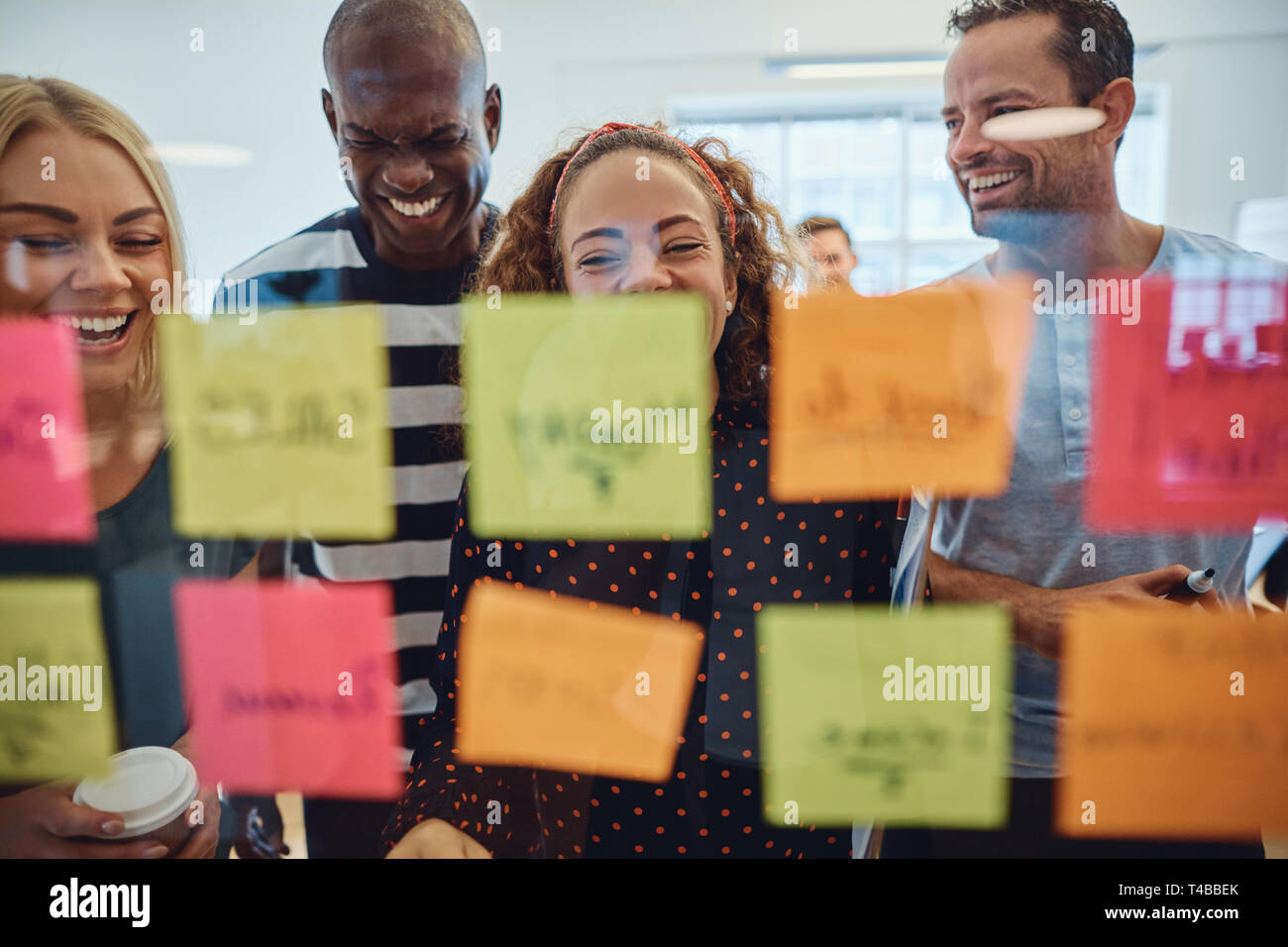 Diverse group of laughing young designers brainstorming together with ...