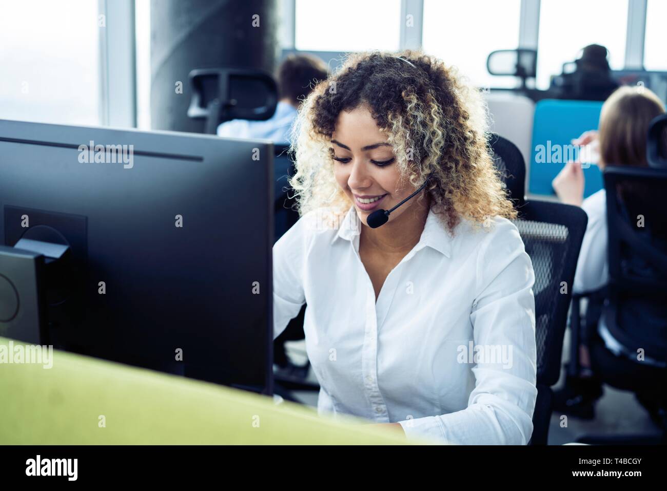 How can I help you? Female customer support operator with headset and smiling Stock Photo - Alamy