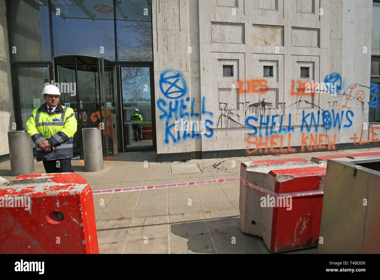 A security guard stands by a graffiti covered Shell building on the ...