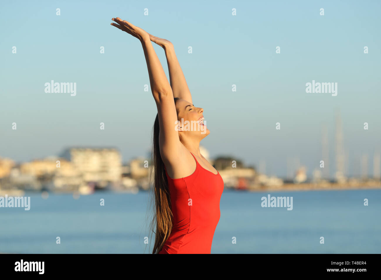 Woman raising arms side view hi-res stock photography and images - Alamy