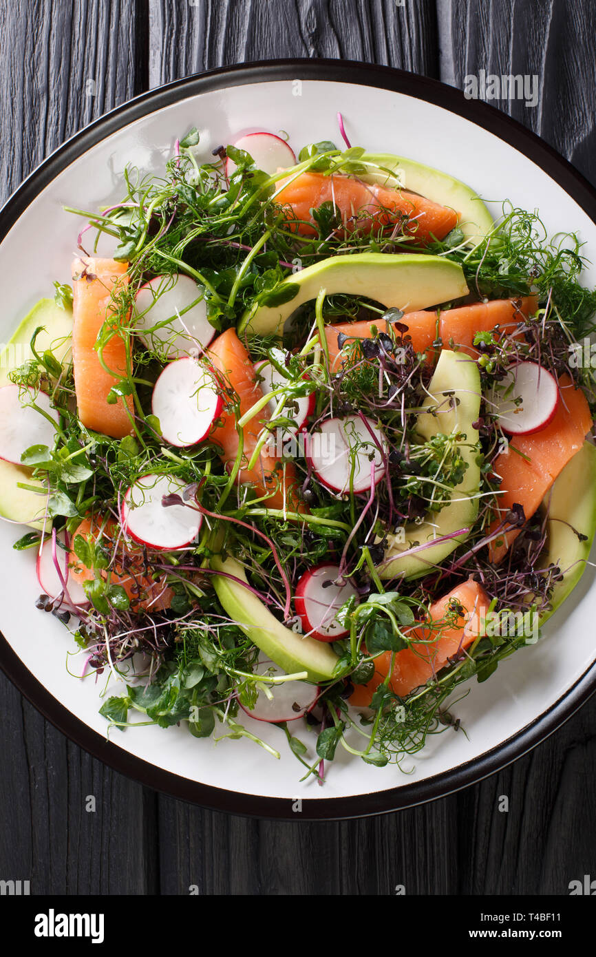 Freshly prepared salad of red fish, avocado, radish and a mix of micro ...