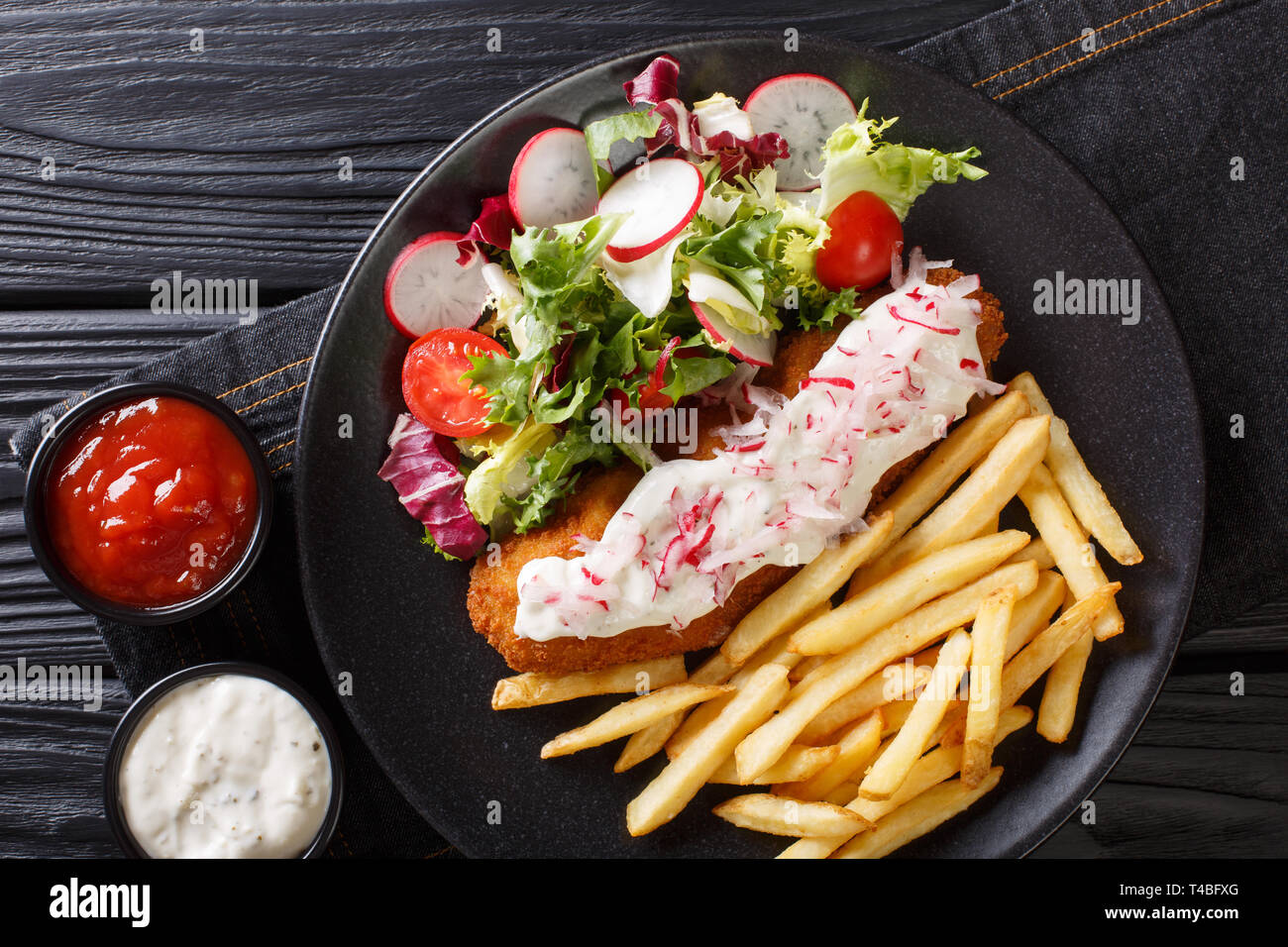 Lunch menu fried pollock with french fries and fresh salad close-up on ...