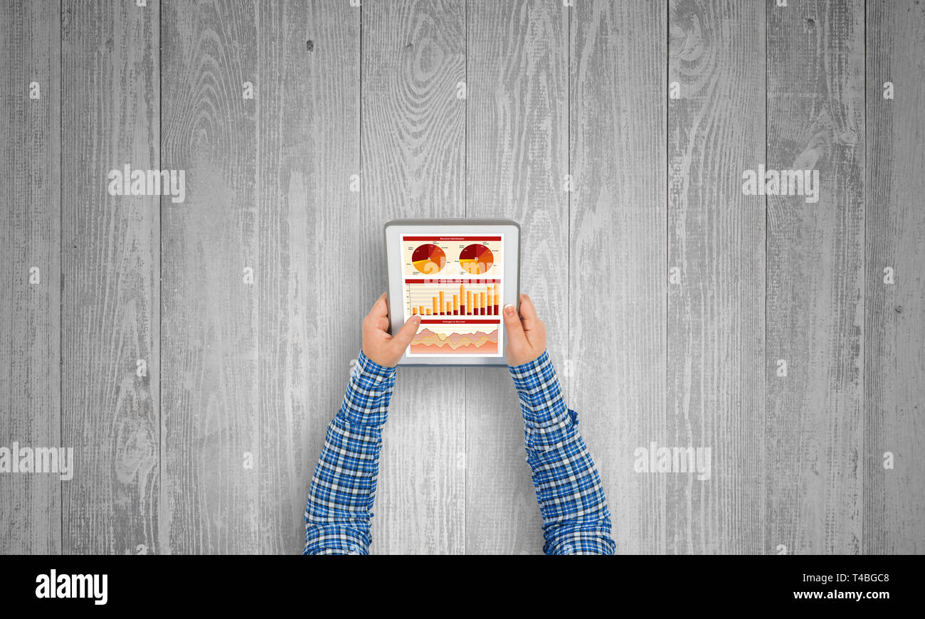 Top view of girl hands using tablet pc with diagrams and graphs on ...