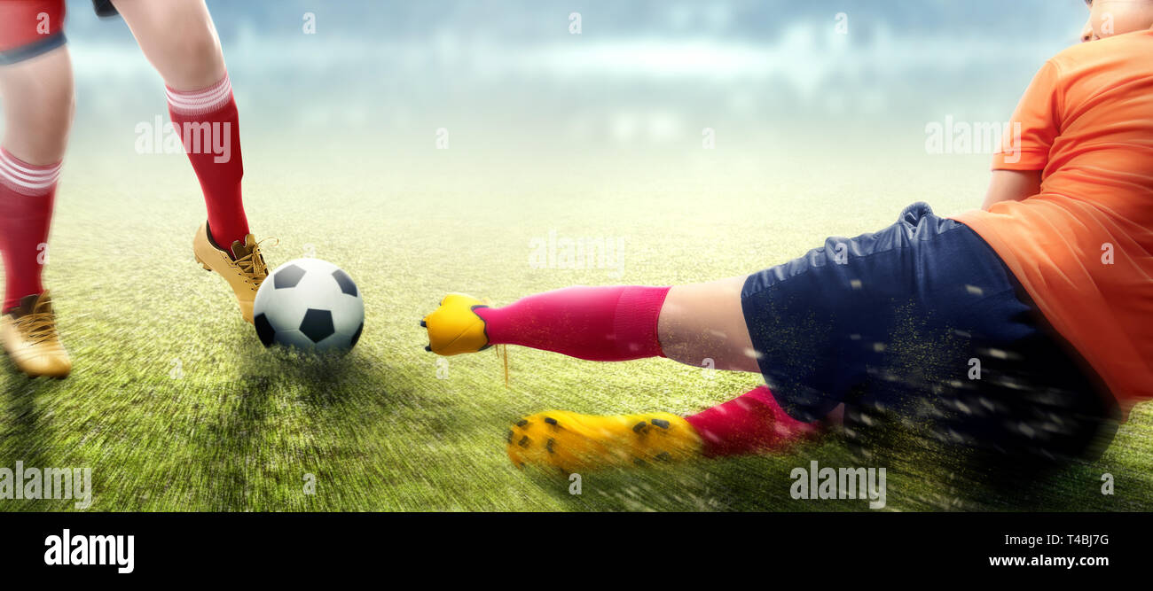 Football player woman in orange jersey sliding tackle the ball from her ...