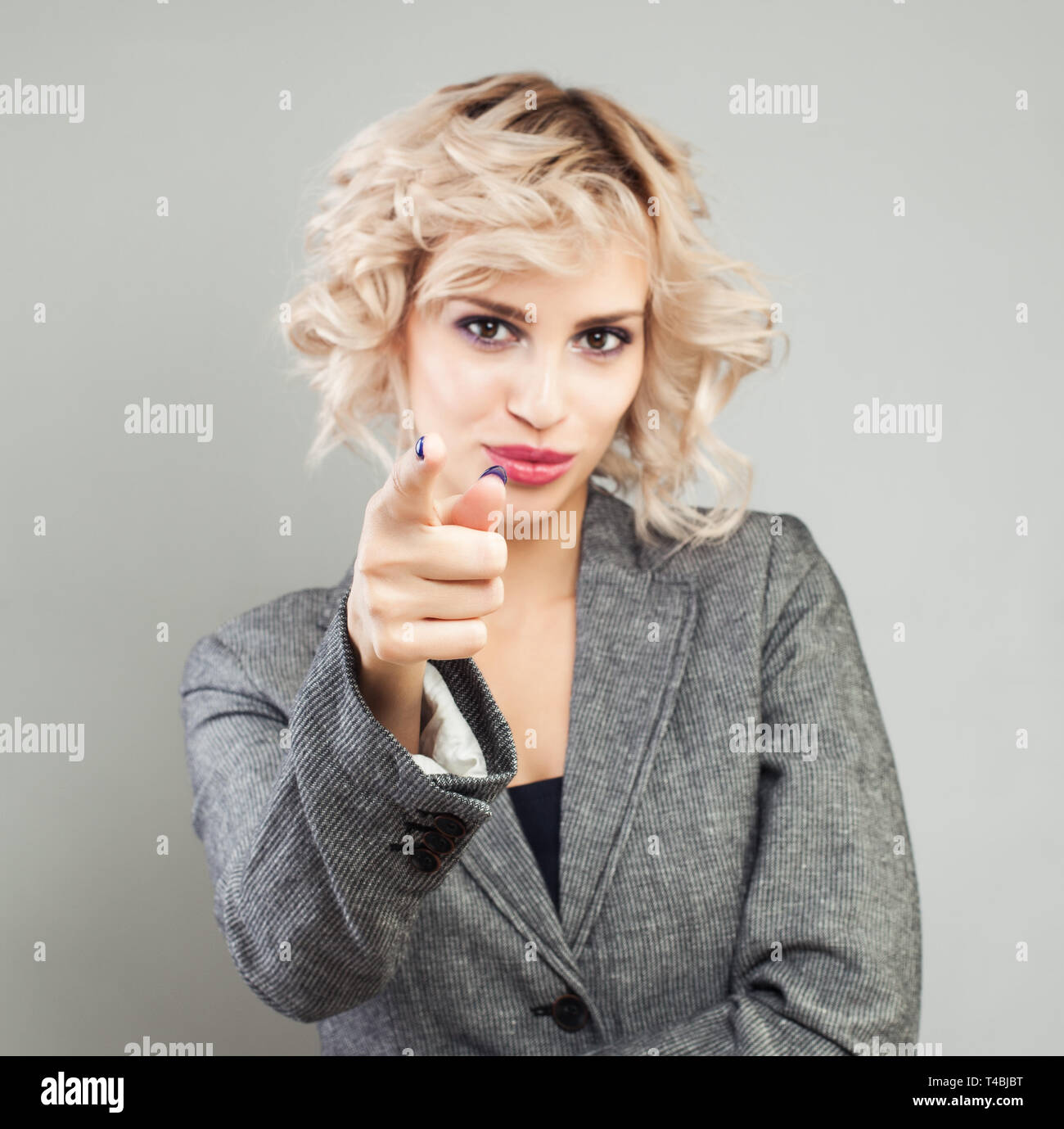 Cheerful blonde woman pointing finger hi-res stock photography and ...
