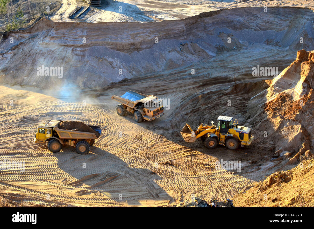 Wheel front-end loader unloading sand into heavy dump truck at the ...