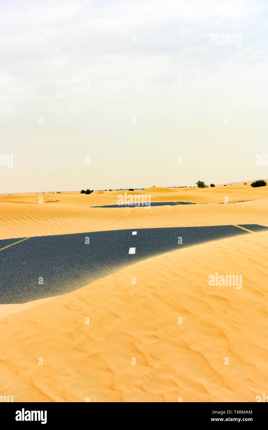 (Selective focus) Stunning view of a deserted road covered by sand ...
