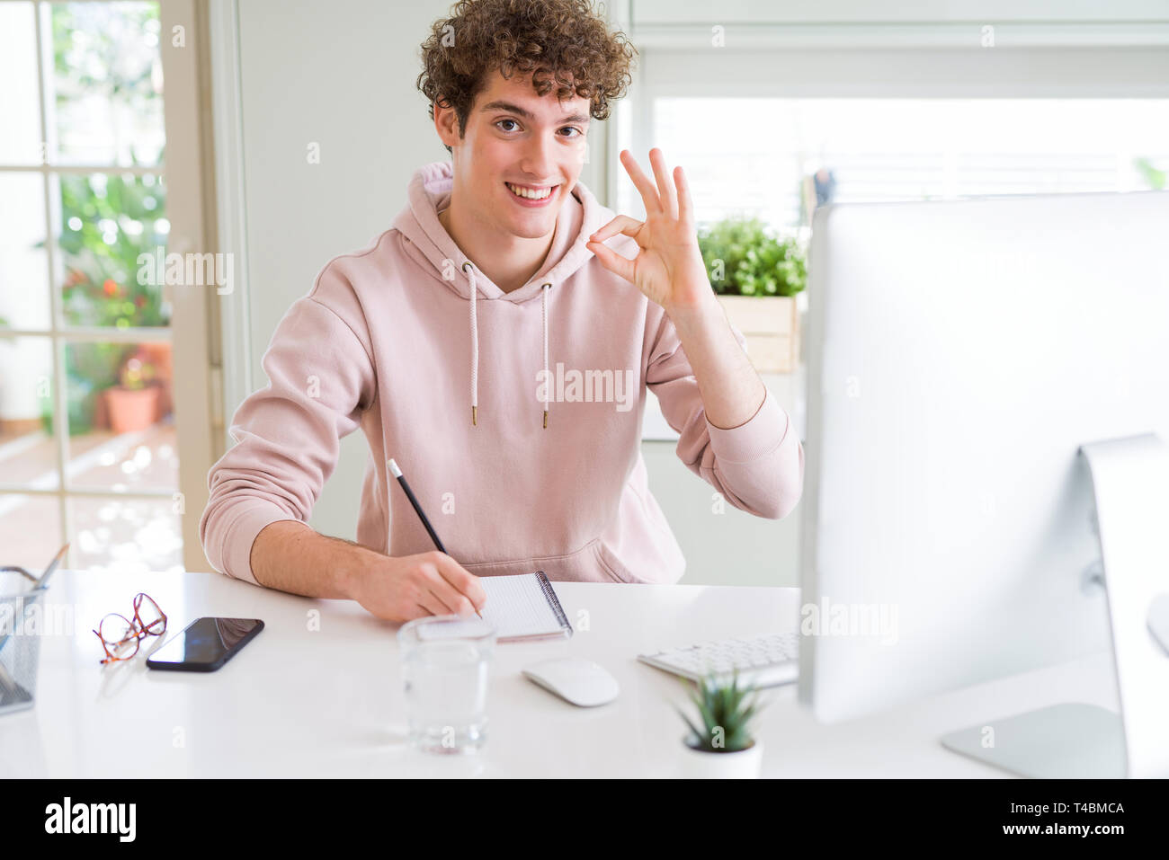 Young student man using computer and studying writing on notebook doing ...