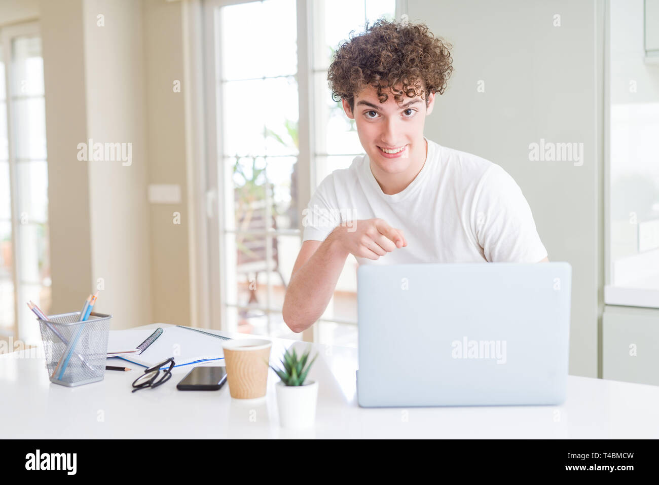 Young student man working and studying using computer laptop very happy ...