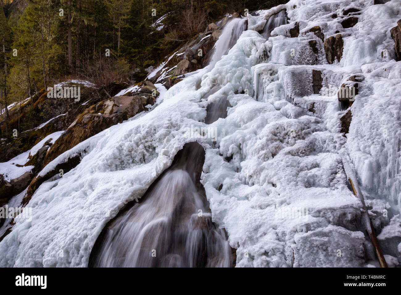 Beautiful view of a waterfall, Crooked Falls, covered in melting ice ...