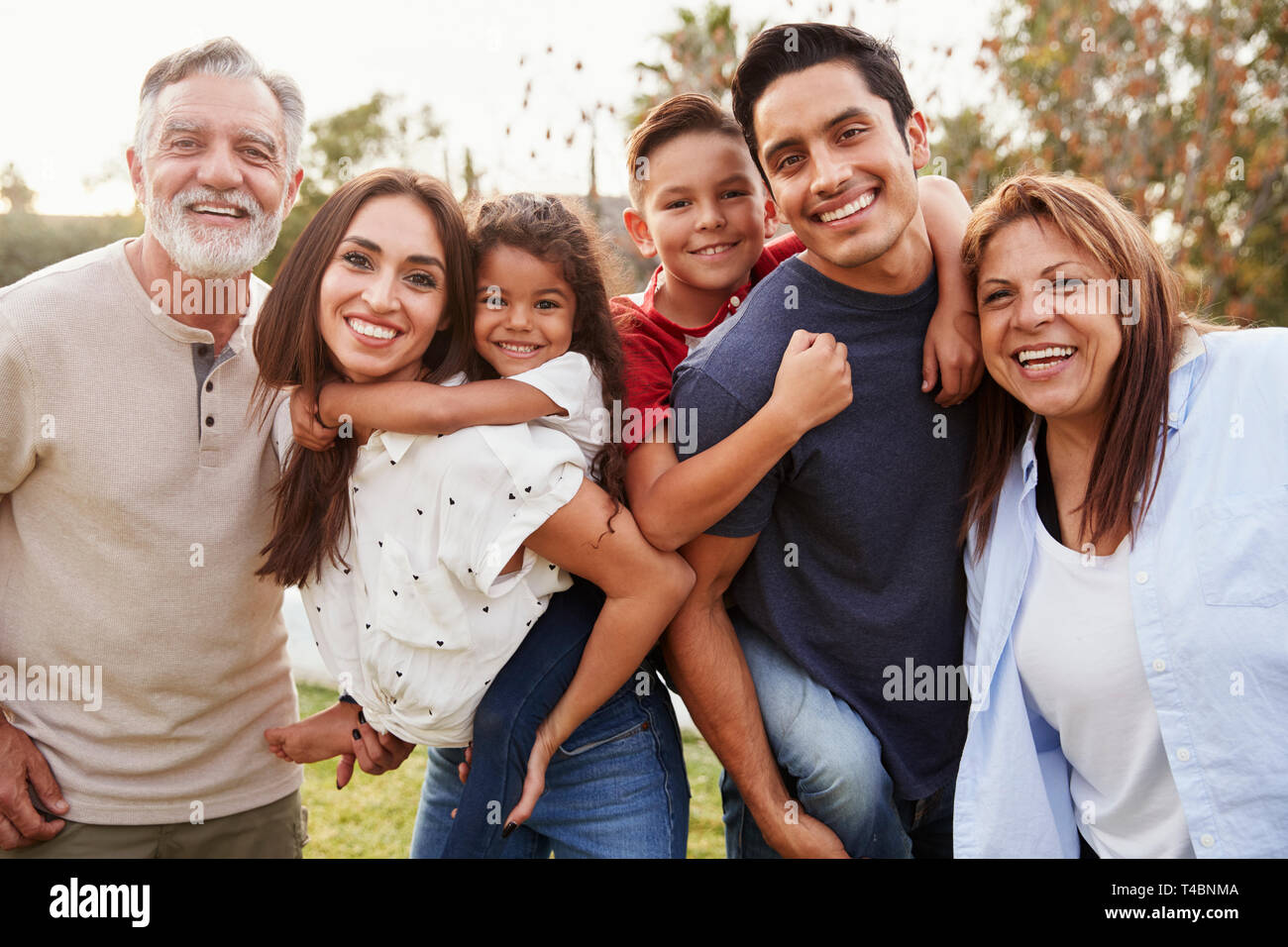 Three generation Hispanic family standing in the park, smiling to ...