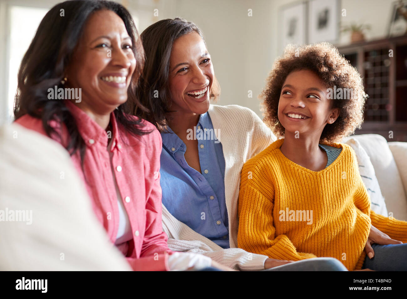 Three generation family female family group sitting on a sofa in the ...