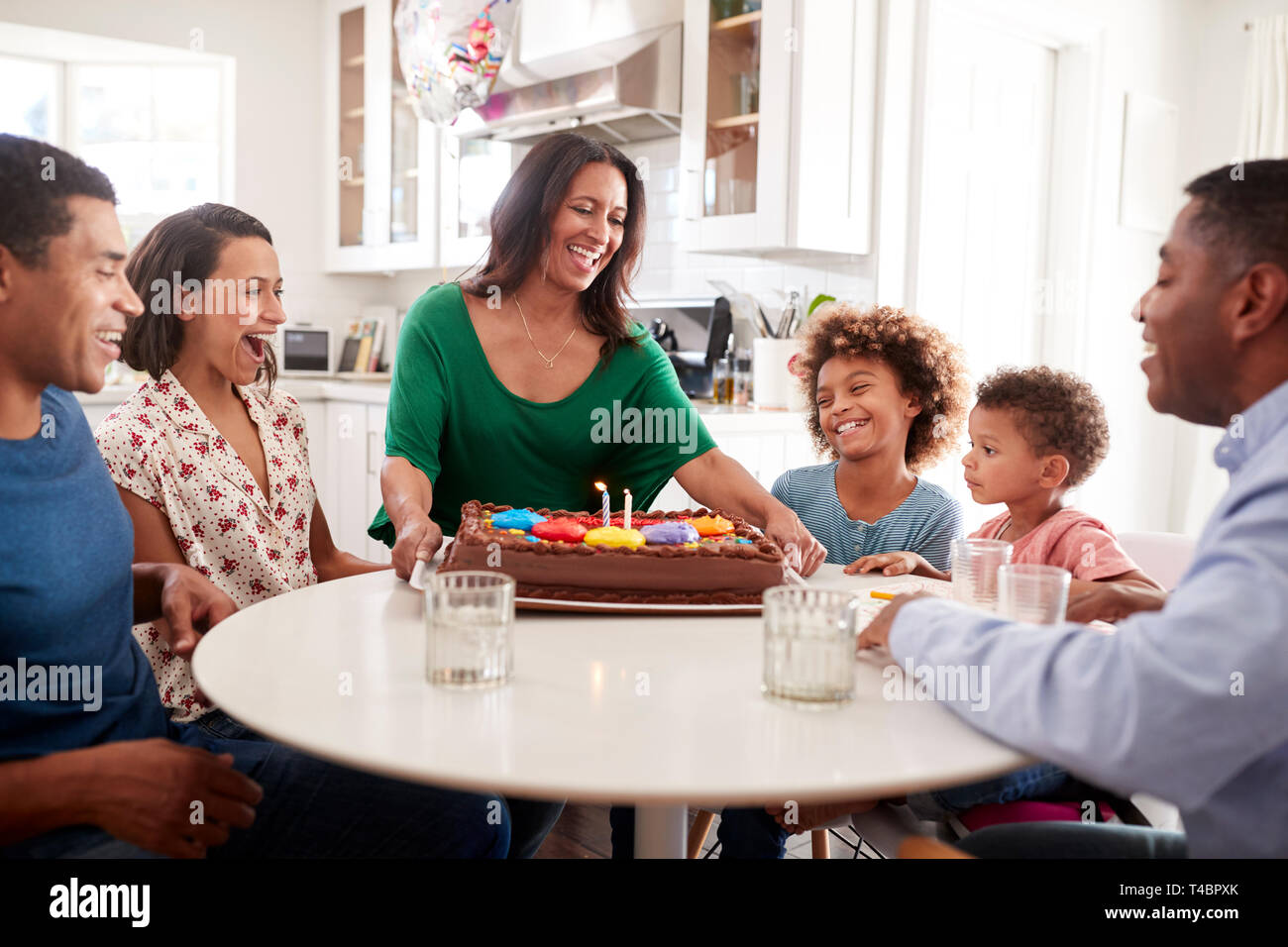 Excited three generation family sitting together in the kitchen ...