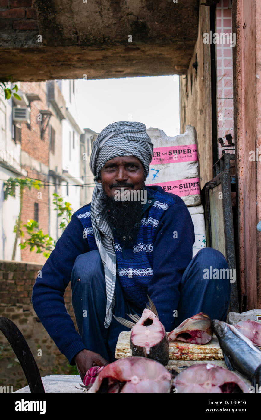 Butcher smiling back at the photographer while chopping the fish in the ...