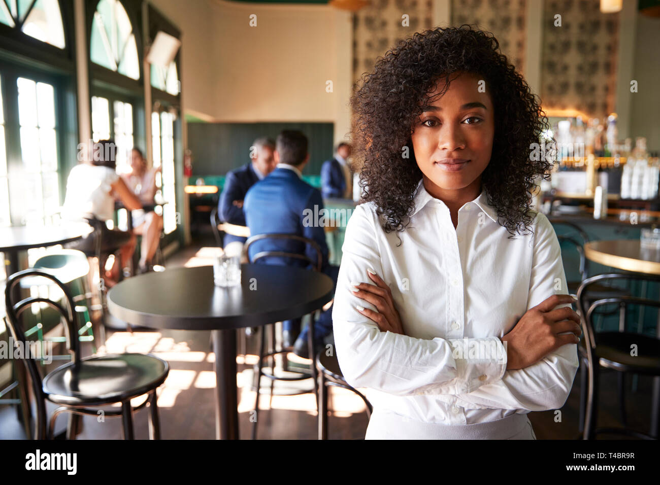 Female Manager Of Busy Cocktail Bar In Restaurant With Customers At ...
