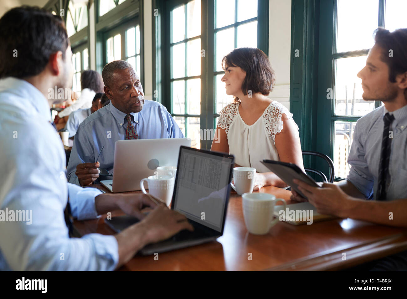 Business Team Having Informal Meeting Around Table In Coffee Shop Stock ...