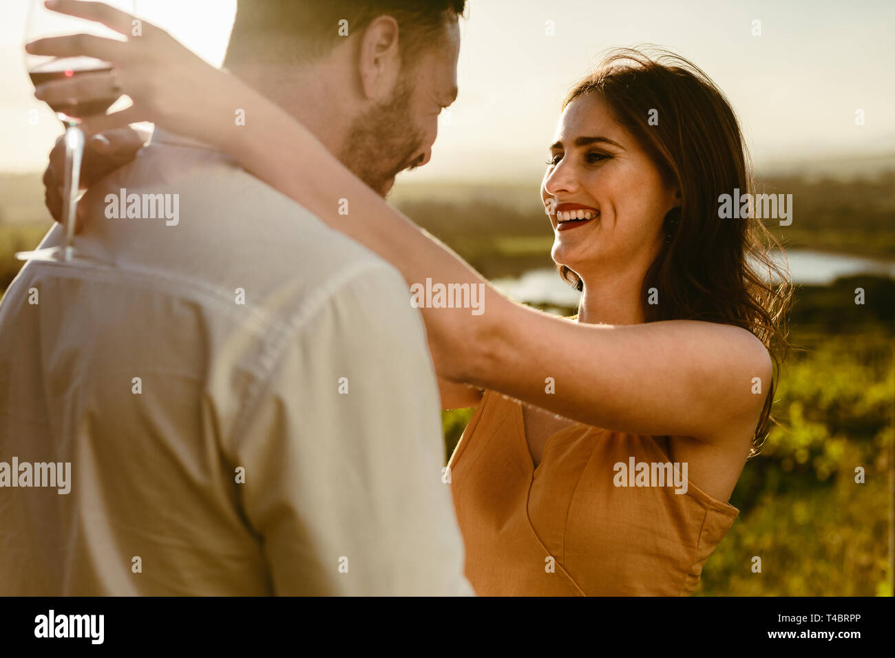 Couple in love standing together holding each other. Side view of a ...