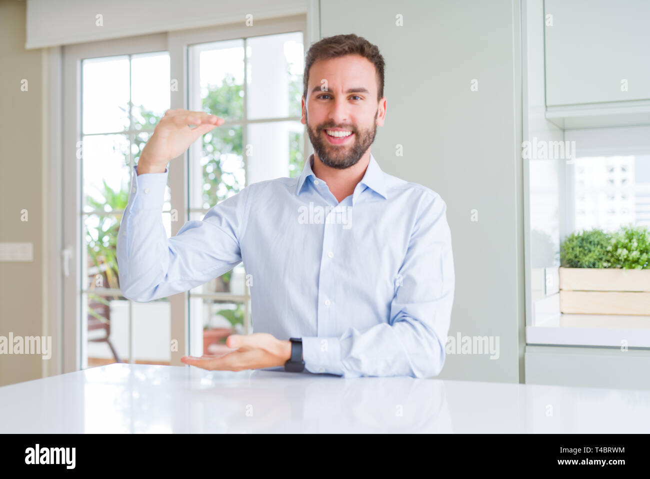 Handsome business man gesturing with hands showing big and large size ...