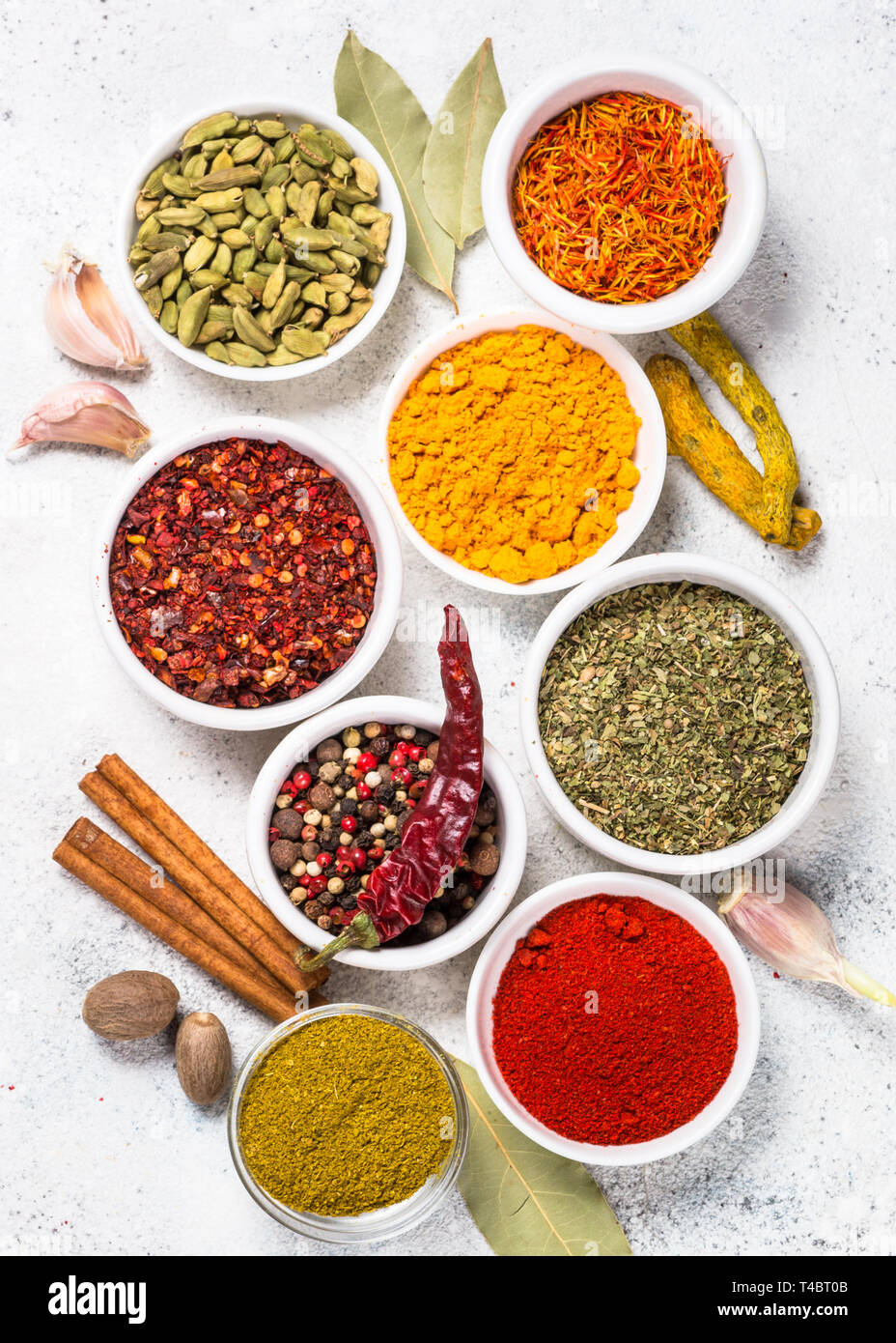 Set of spices over white stone table. Curry, turmeric, peppercorn ...
