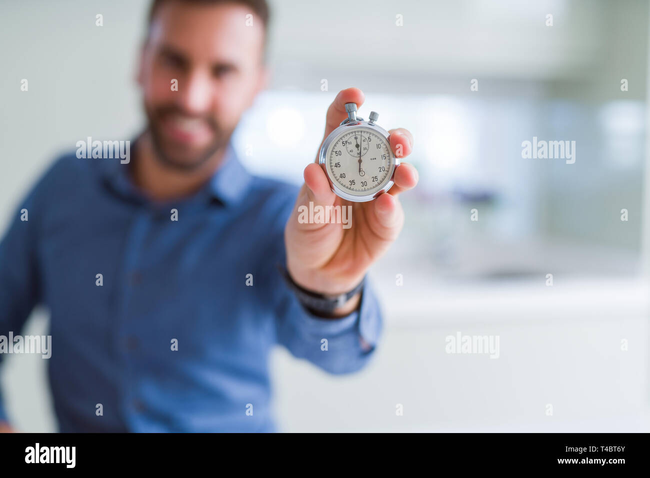 Handsome man showing stopwatch Stock Photo - Alamy