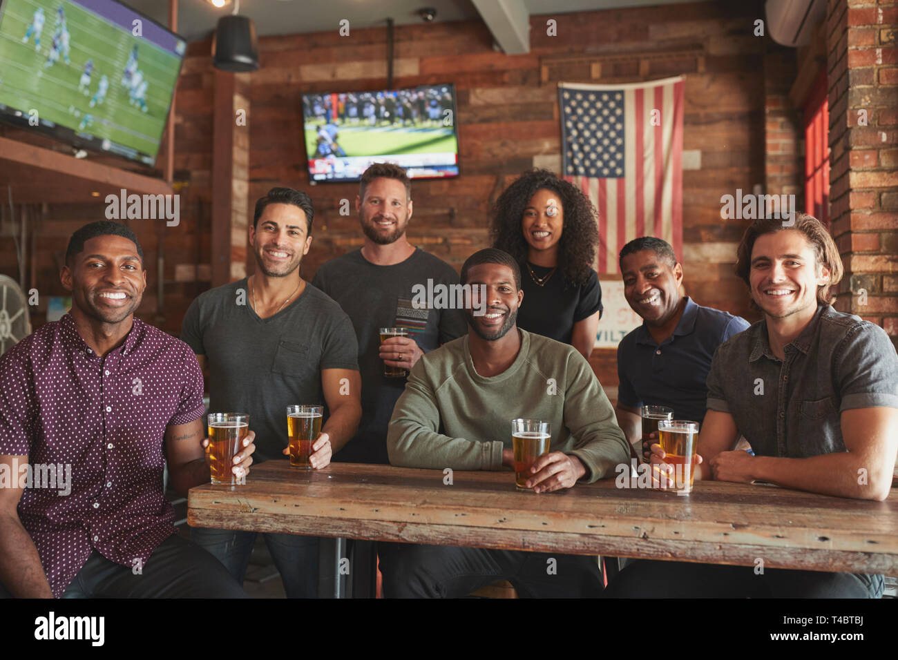 Group Of Friends Meeting And Drinking Beer In Sports Bar Together At ...