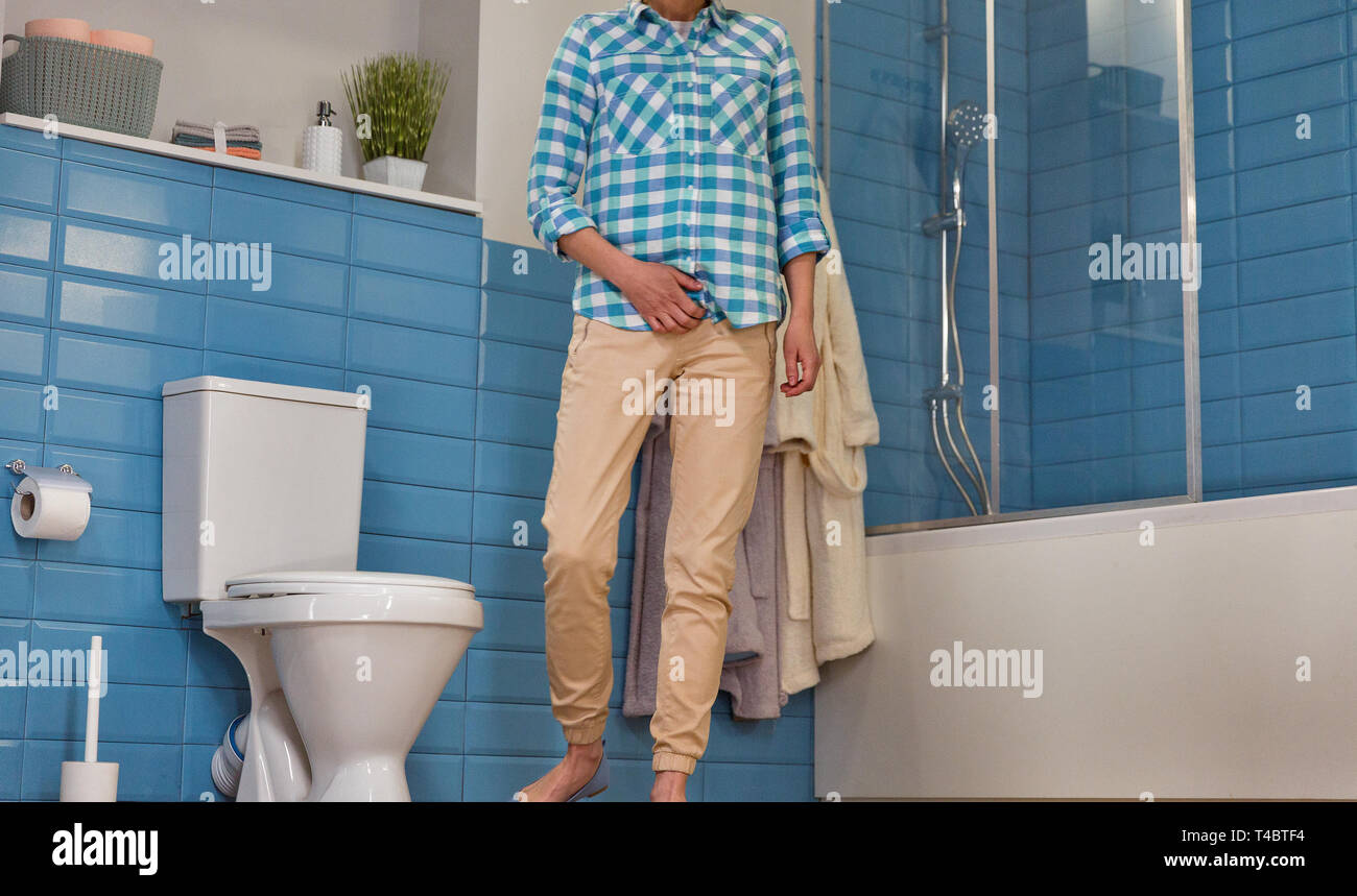 dressed young caucasian woman has pain in the lower abdomen in the ...