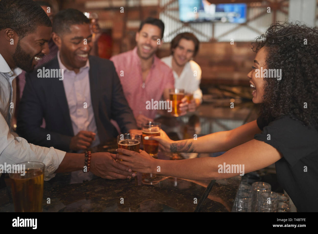 Barmaid Serving Group Of Male Friends On Night Out For Bachelor Party ...