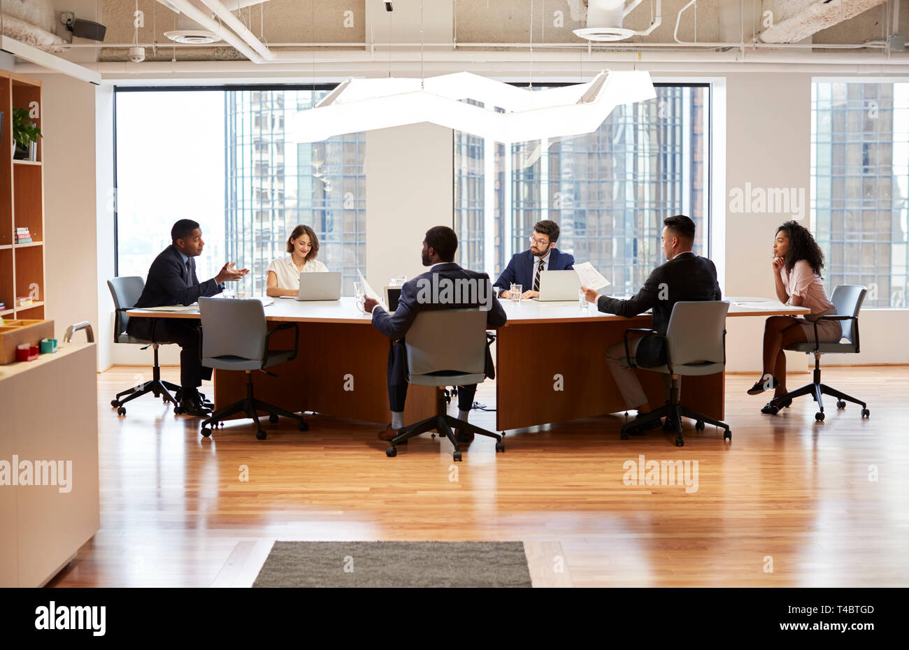 Group Of Business Professionals Meeting Around Table In Modern Office ...