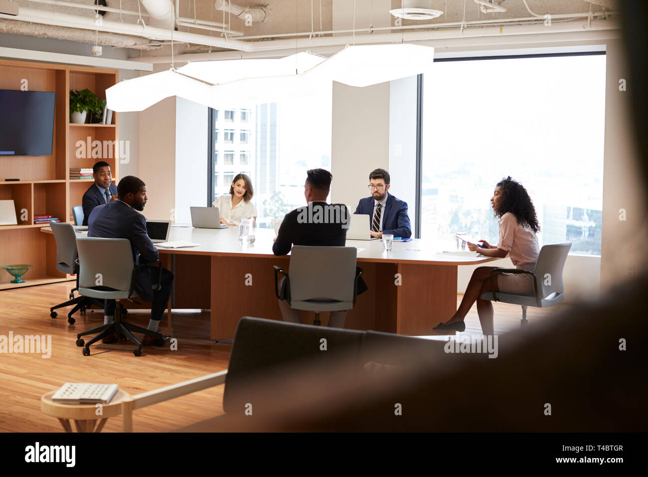 Group Of Business Professionals Meeting Around Table In Modern Office ...
