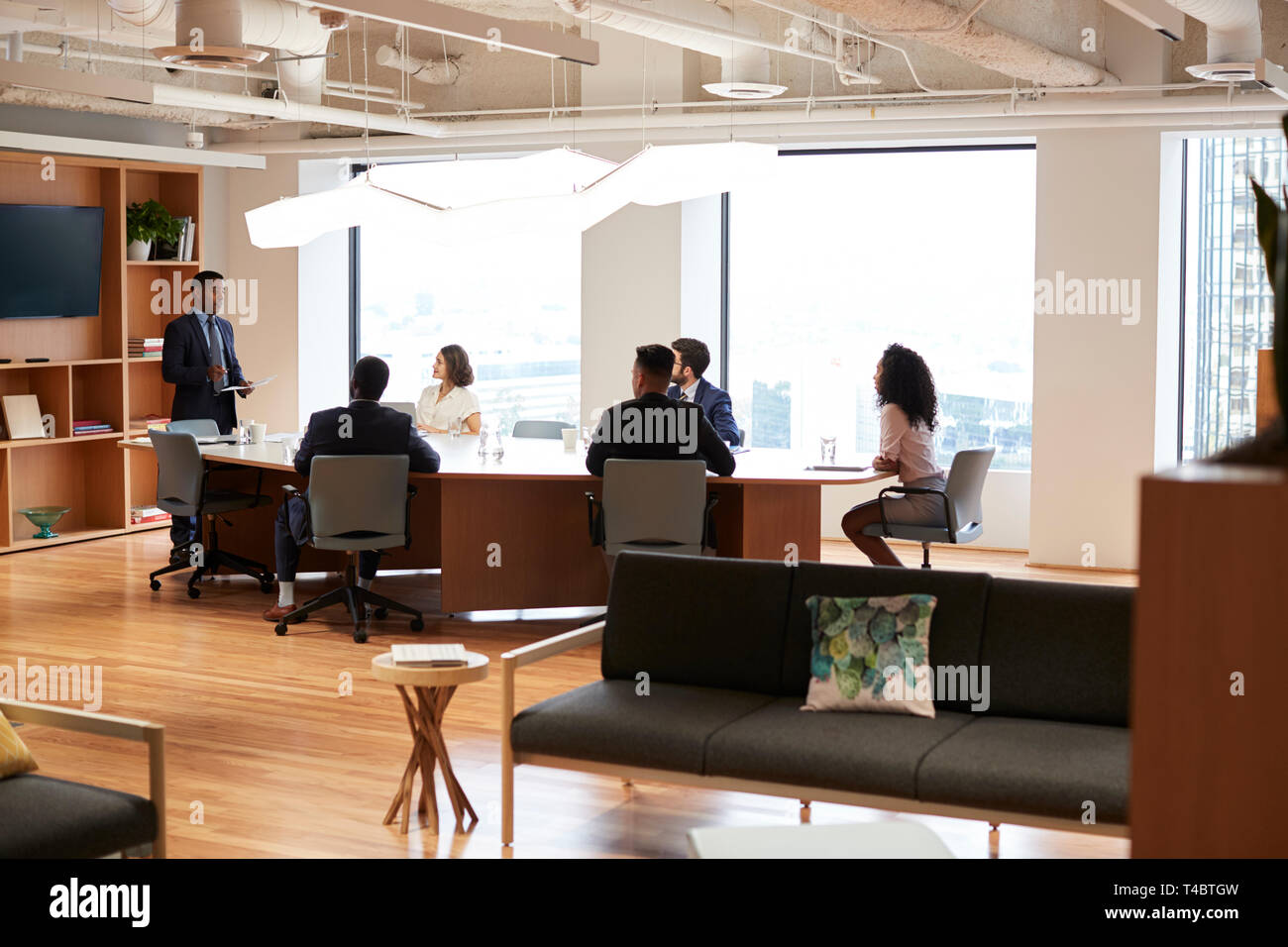 Group Of Business Professionals Meeting Around Table In Modern Office ...