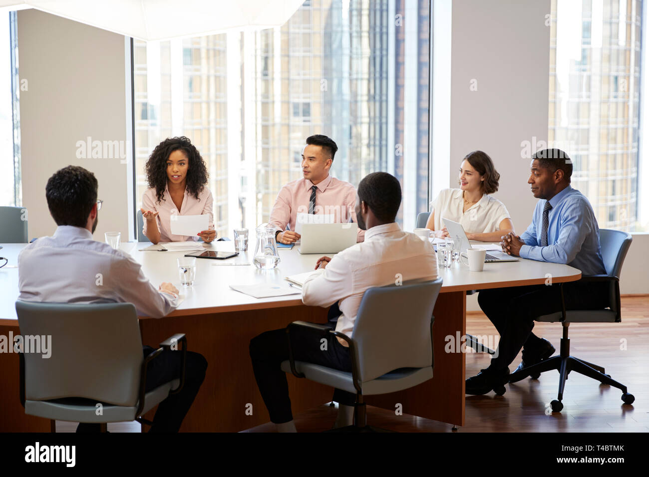 Group Of Business Professionals Meeting Around Table In Modern Office ...