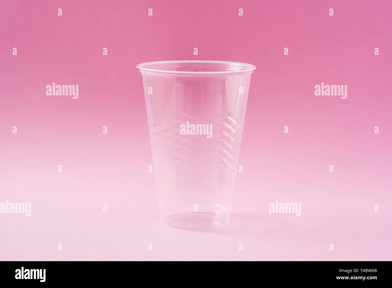 Disposable waste plastic glass on pink background Stock Photo - Alamy