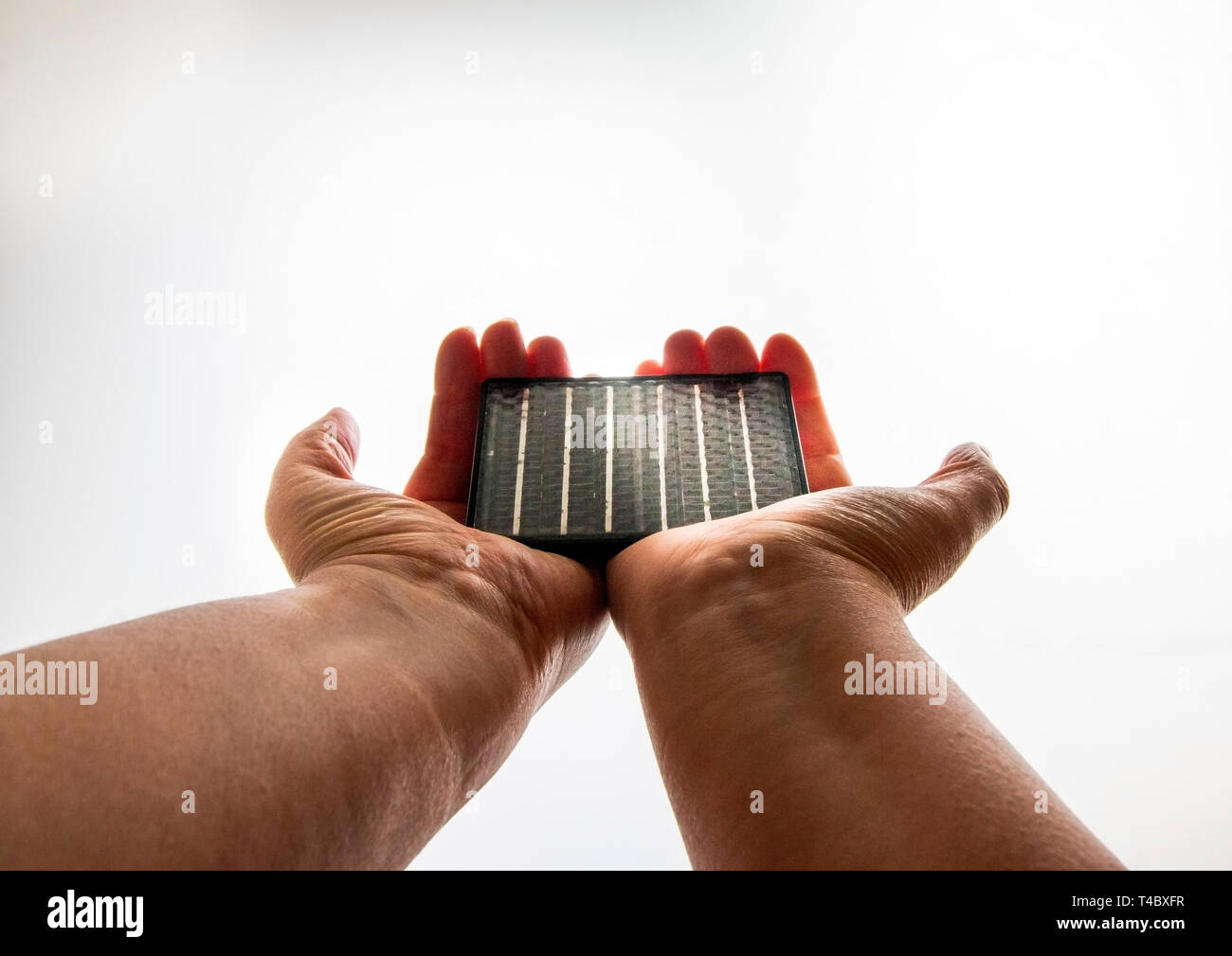 Two hands holding a solar panel set against a white background Stock ...