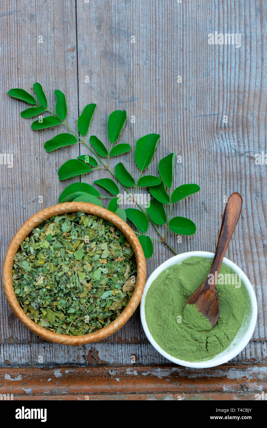 Moringa, Moringa-Pulver in Schale mit Holzloeffel, getrocknete und ...