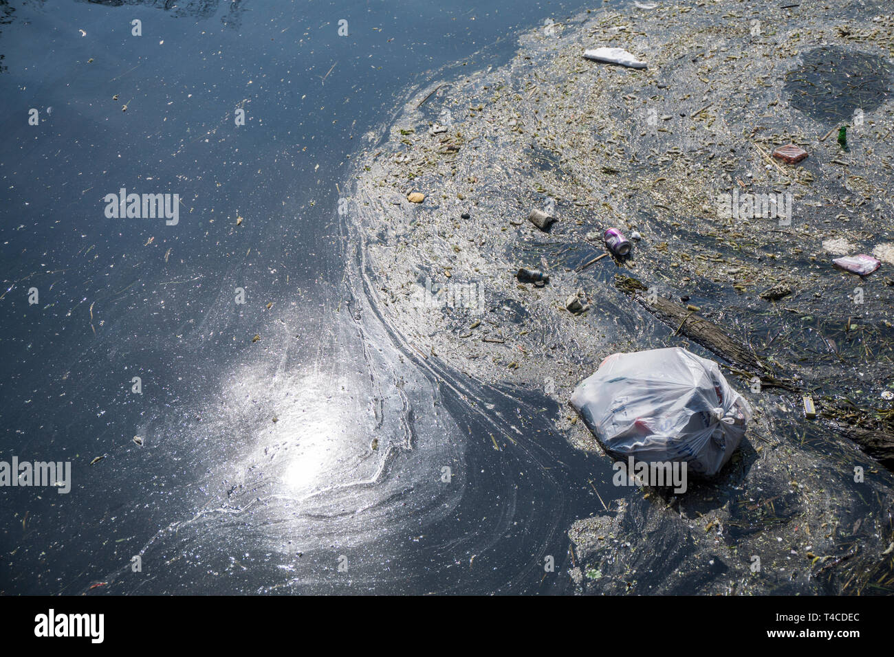 Plastic waste polluting into nature. rubbish bag floating on water ...
