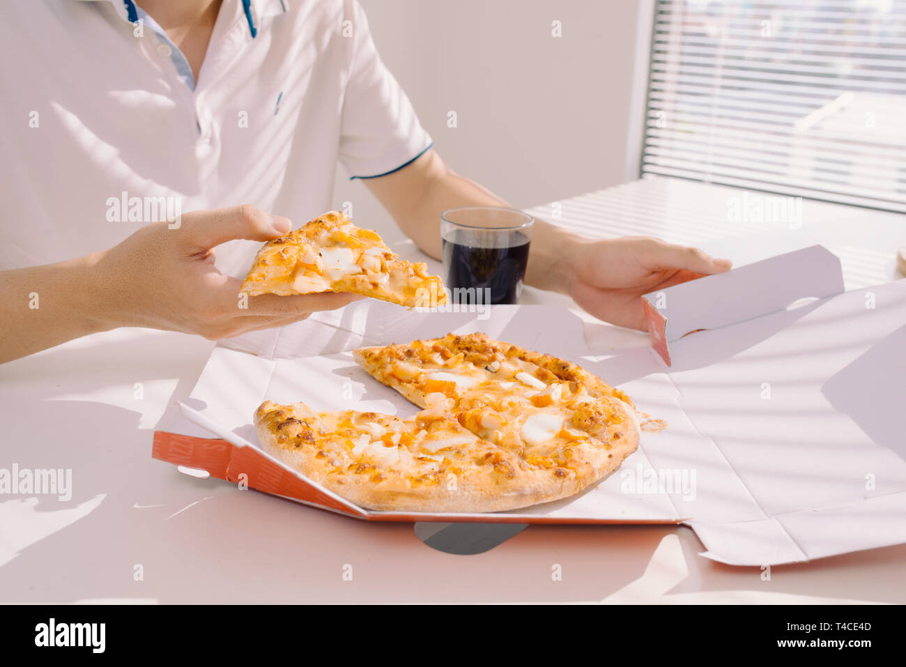 Male freelancer eating pizza while working at home office Stock Photo ...