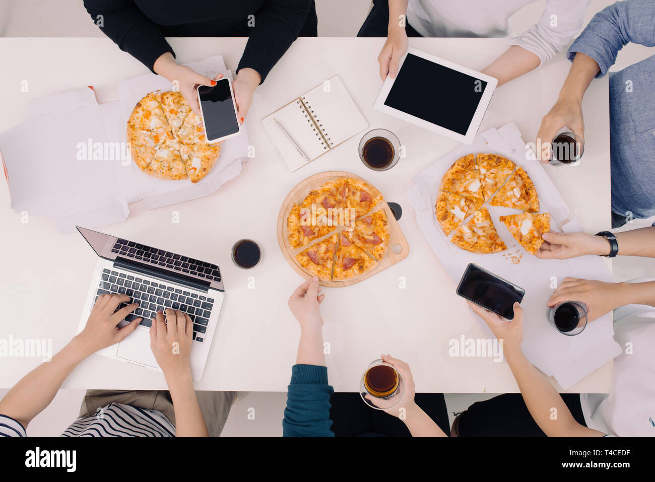Business team is eating pizza at work while working Stock Photo - Alamy