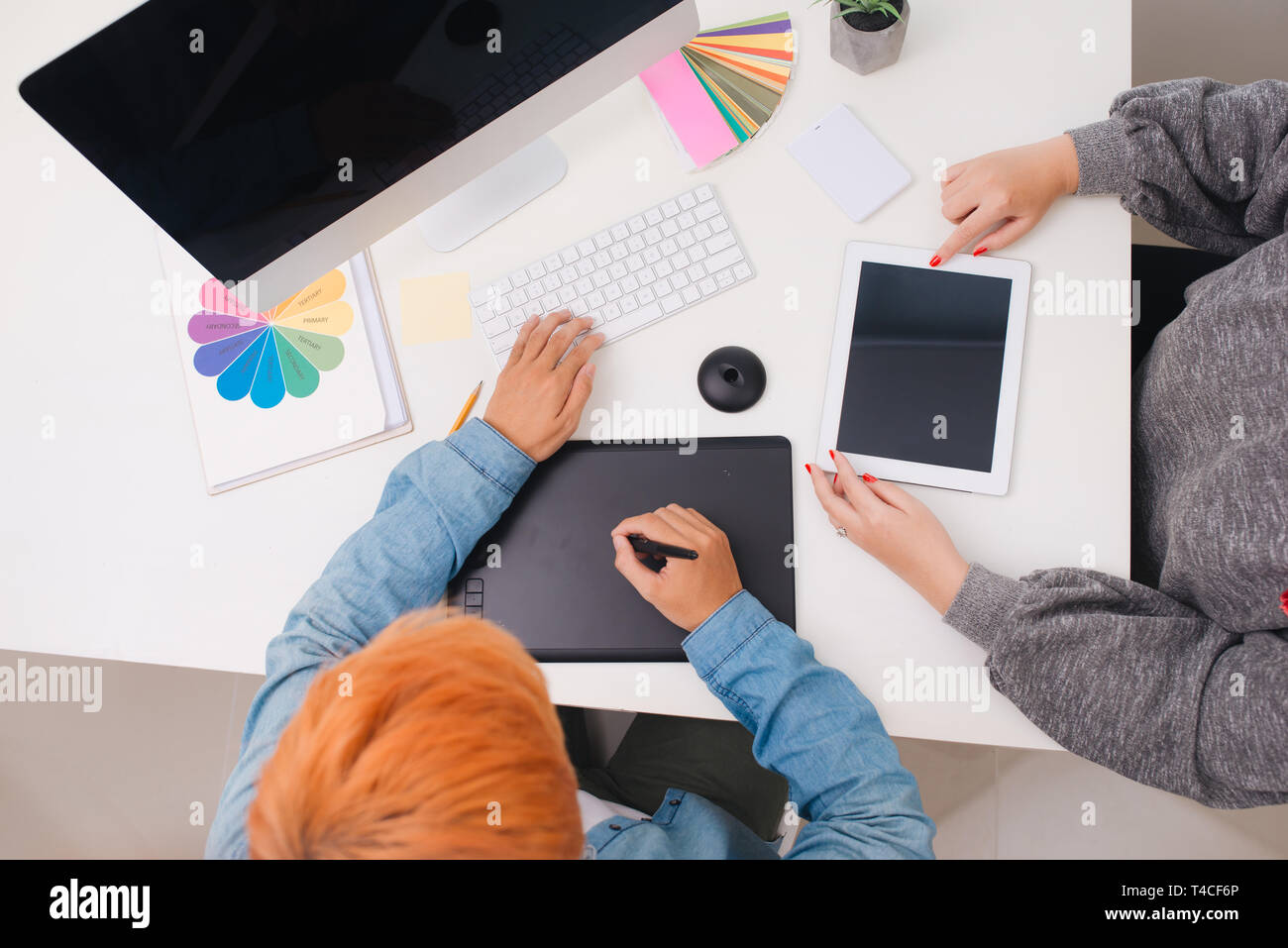 Graphic designers discussing over computer in modern office Stock Photo ...