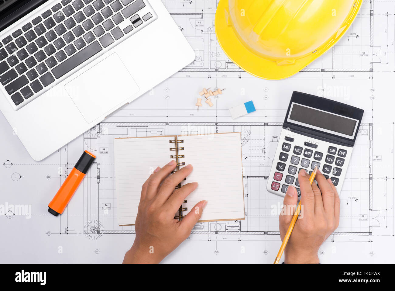 Hand over Construction plans with yellow helmet and drawing tools on ...