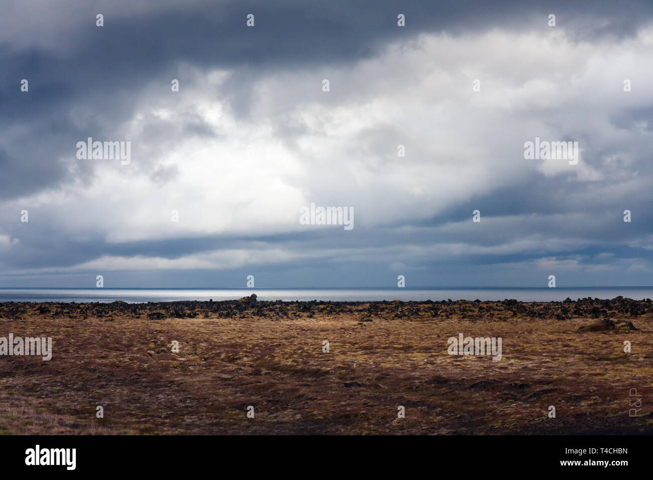 landscape with horizon line, water and high clouds and sunshine ...
