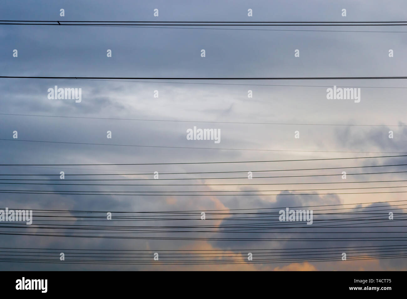 Multiple horizontal high voltage cable lines across stormy clouds, at ...